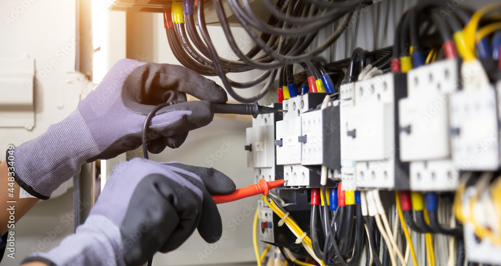 Electrician engineer tests electrical installations and wires on relay ...