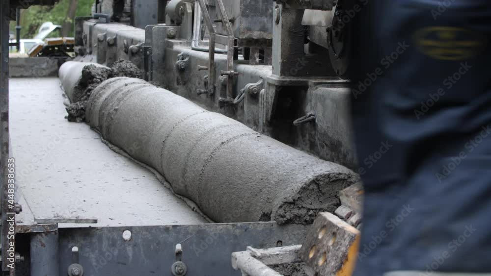 Close-up view of road screed paver, roller or vibrator flattening ...