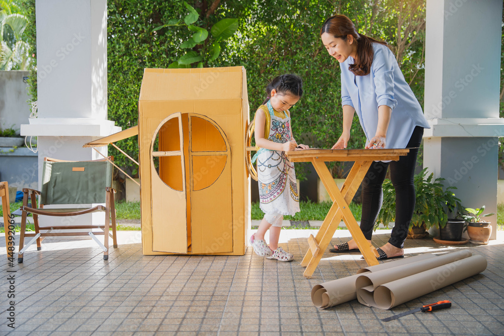 Children kids girls and mother hand making paper house at home. Asian ...