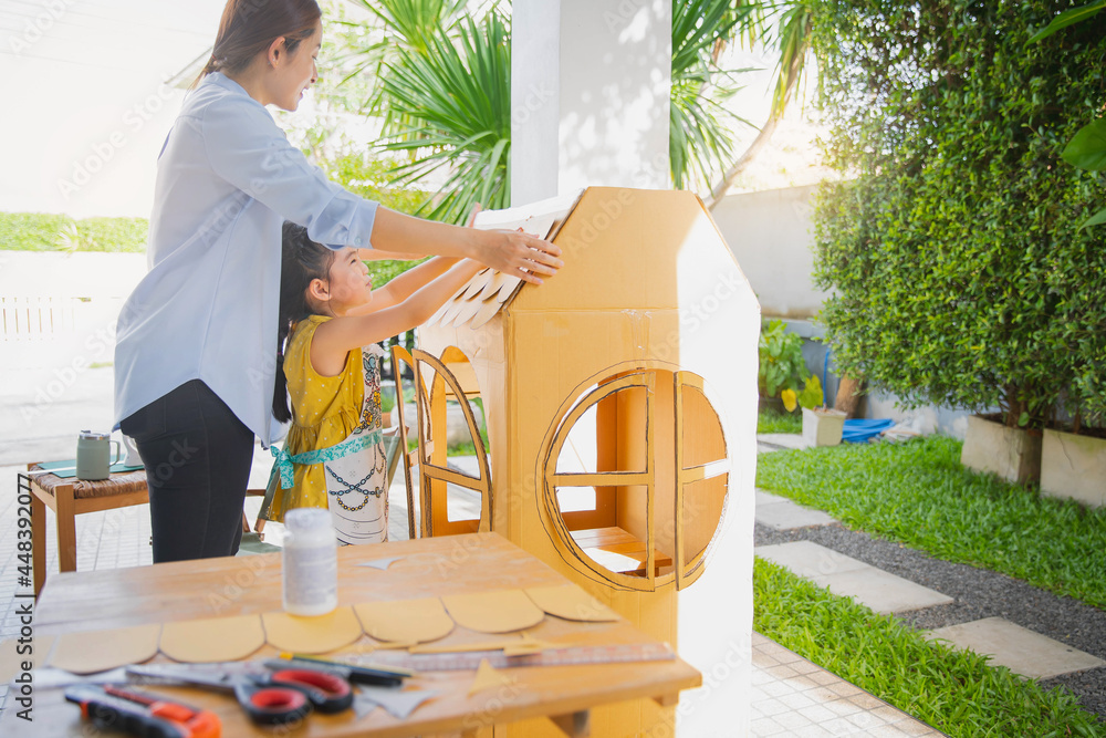 Children kids girls and mother hand making paper house at home. Asian ...