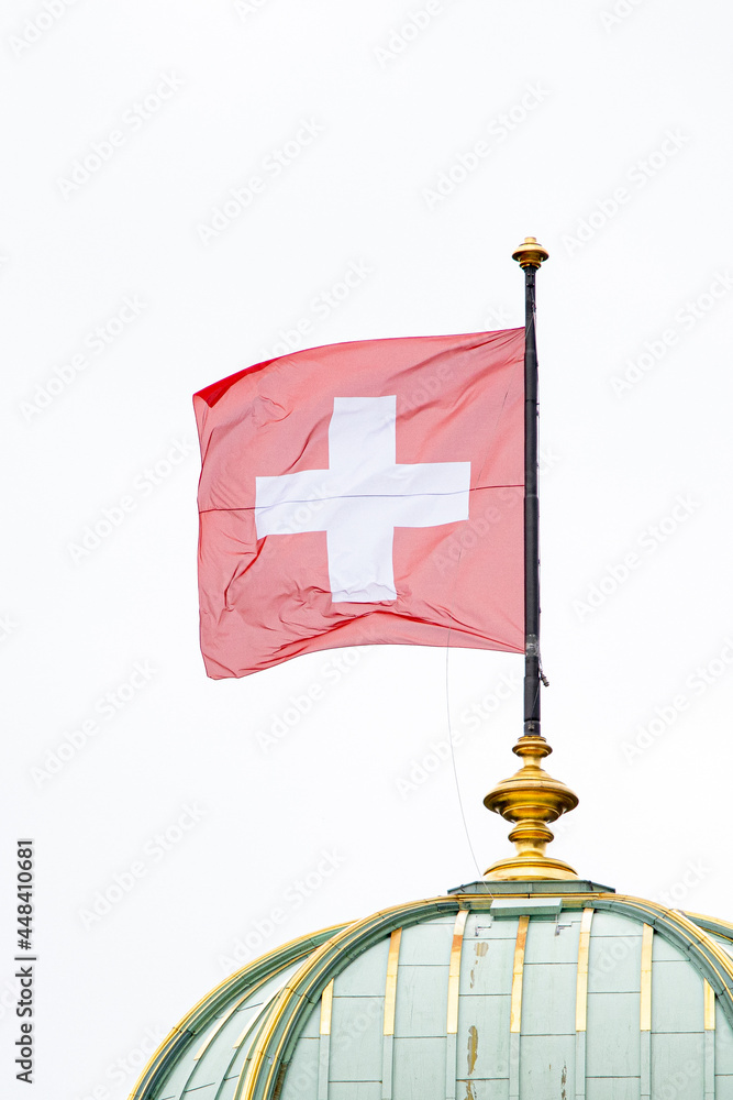 The red Swiss Flag with the white cross on red background on top of the ...