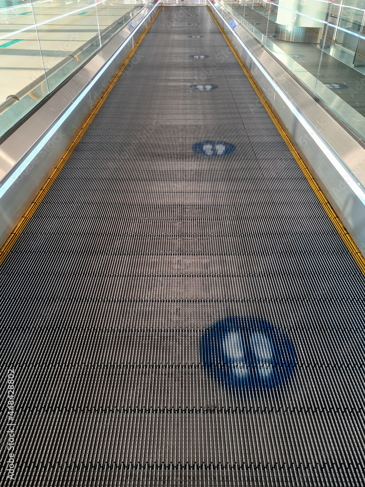 Social distancing footprint marks and the travelator belt in the ...