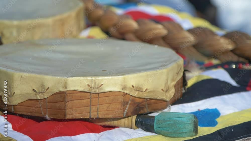 Close up on a native hand drum, drumstick and sweetgrass braid at a ...