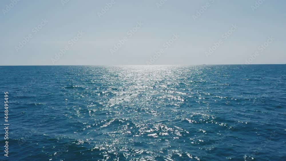 Low flight above rippled endless blue sea or ocean. Glittering water ...