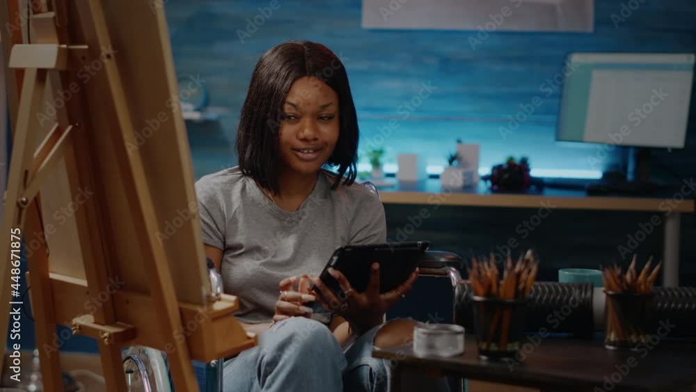 Paralyzed african american artist using digital tablet at art studio ...
