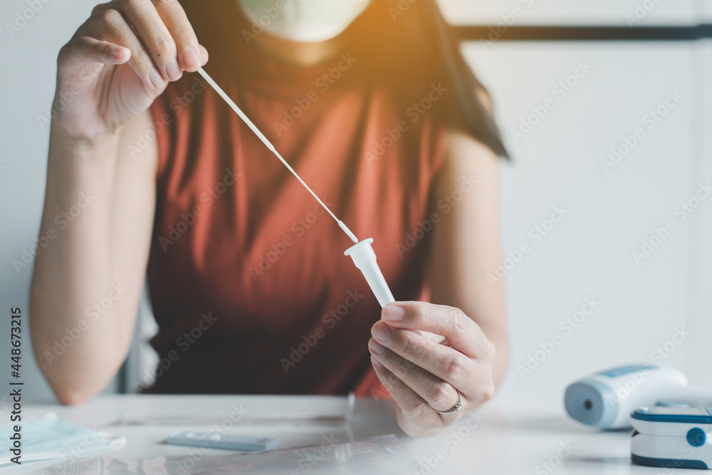Patient woman using a covid-19 self test rapid antigen testing kit at ...