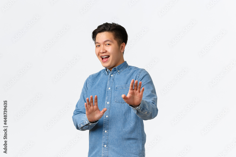Asian guy feeling awkward, apologizing and step back, raising hands up ...