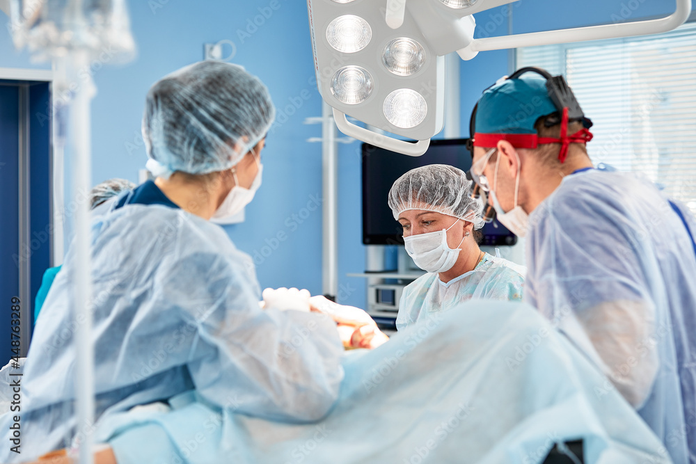 Surgeons during surgery with breast implants in their hands ...