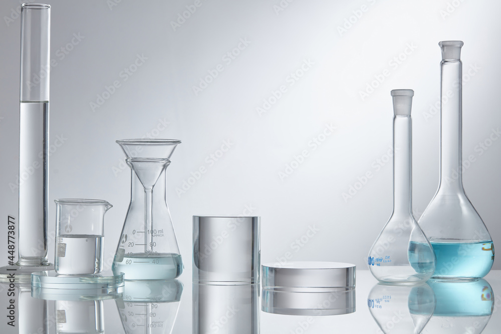 Laboratory glass equipment with blue water ingredients on white ...