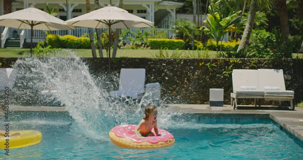 Happy young diverse family playing in the pool on summer vacation ...