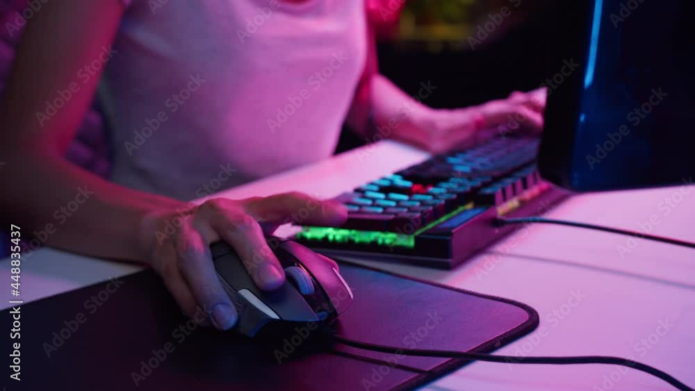 Woman gamer hands using wired computer mouse and typing on neon ...
