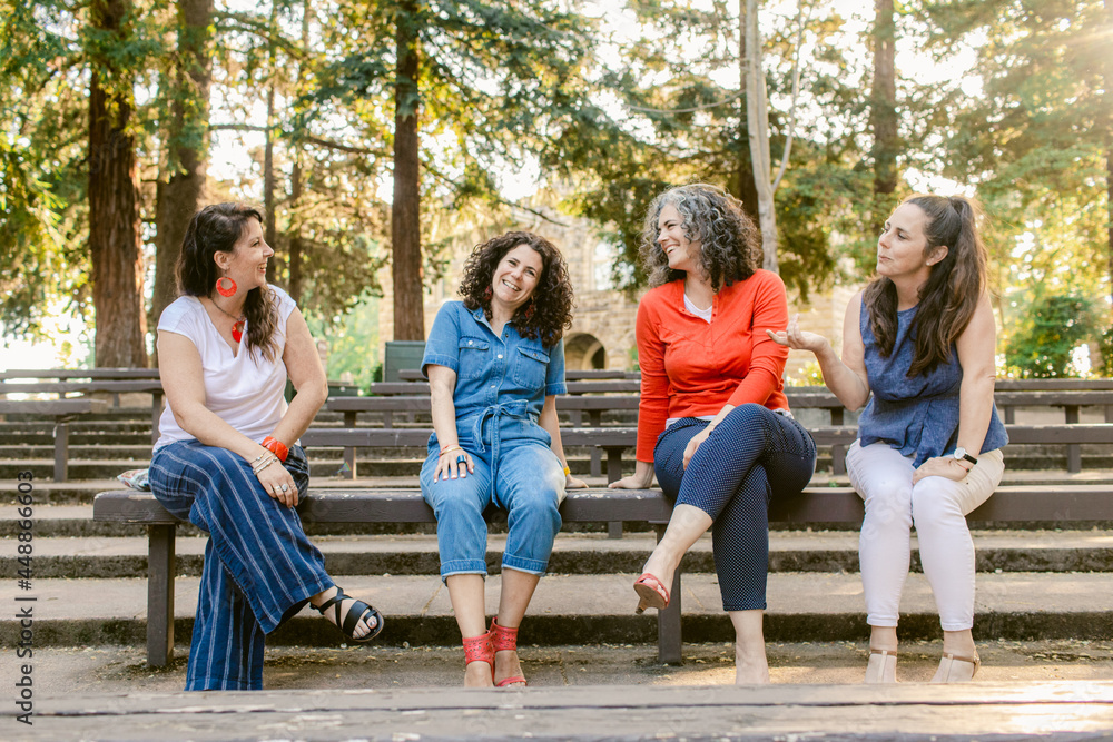 Smiling mature women talking to each other in park Stock Photo | Adobe ...