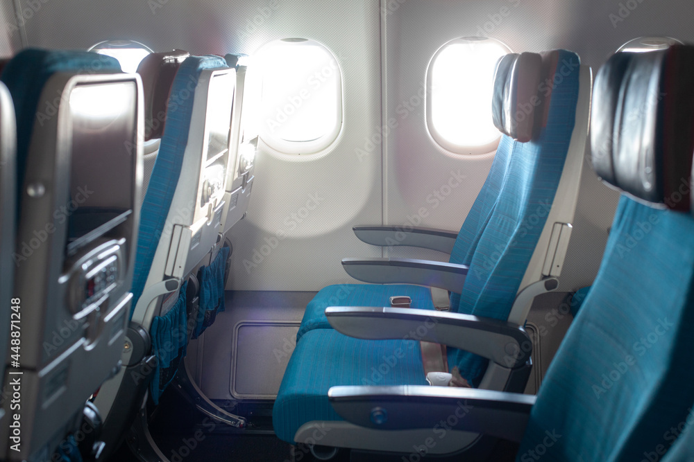 seats in economy class of passenger airplane Stock Photo | Adobe Stock