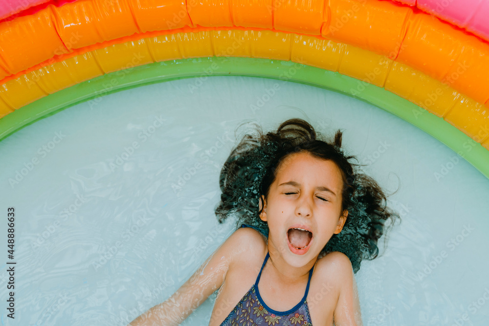 Kid getting wet in inflatable colorful swimming pool Stock Photo ...