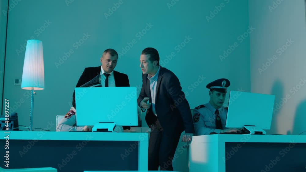 Police detectives working together in computer room to try and solve a ...
