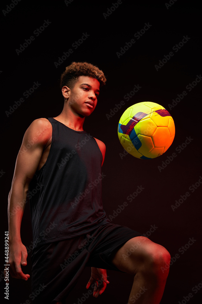 Black sportsman kicking soccer ball Stock Photo | Adobe Stock