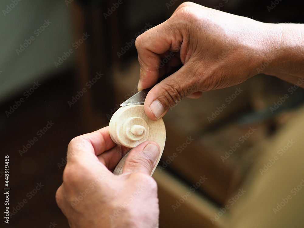 Luthier carving a classic violin head and curl with a small knife in ...