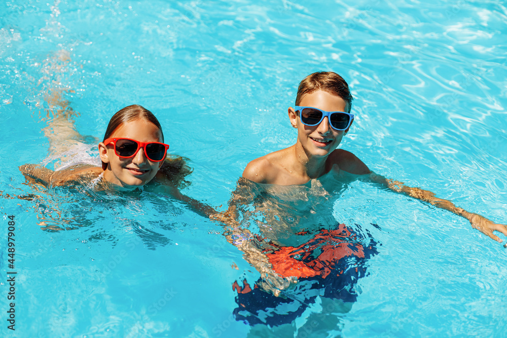 Children playing in the pool, kids having fun playing and swimming in ...