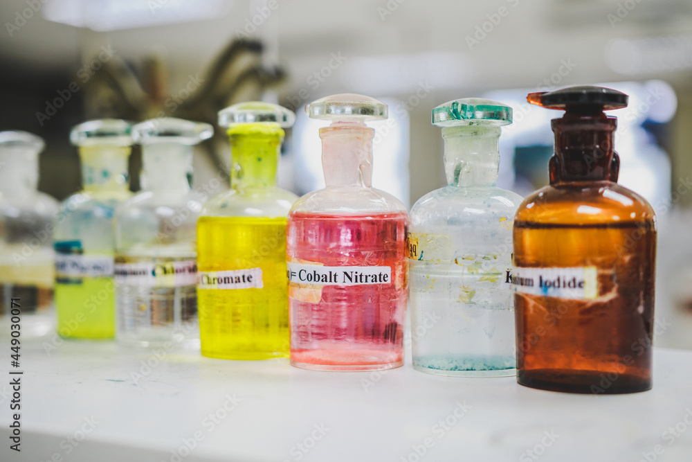 Chemical bottle containing colorful fluid chemical with label sticker ...