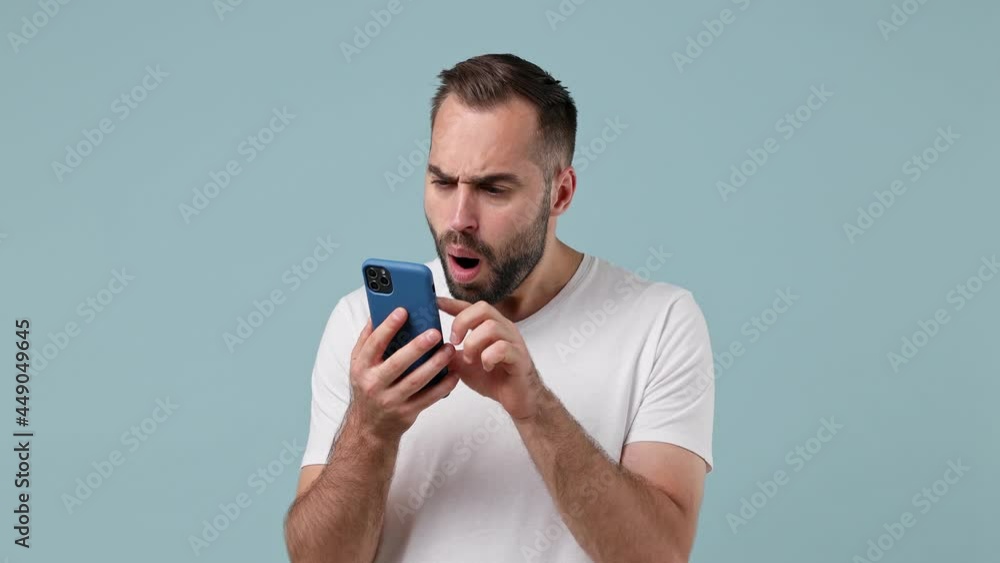 Irritated frustrated young brunet man 20s wears white t-shirt using ...