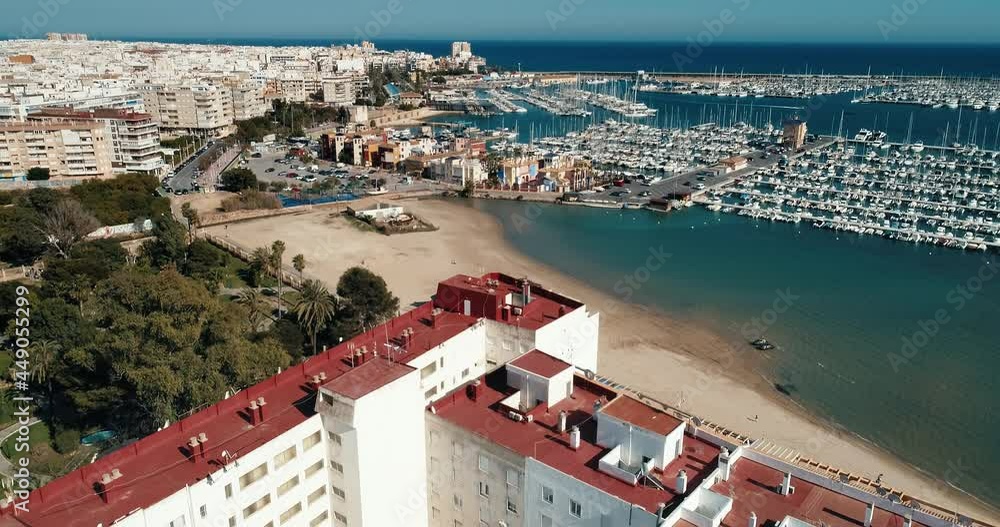 Drone flies over building and beach approaches to the yachts port in ...