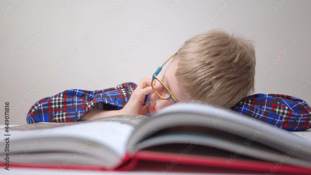 schoolboy fell asleep while reading book boy with glasses. tired of ...
