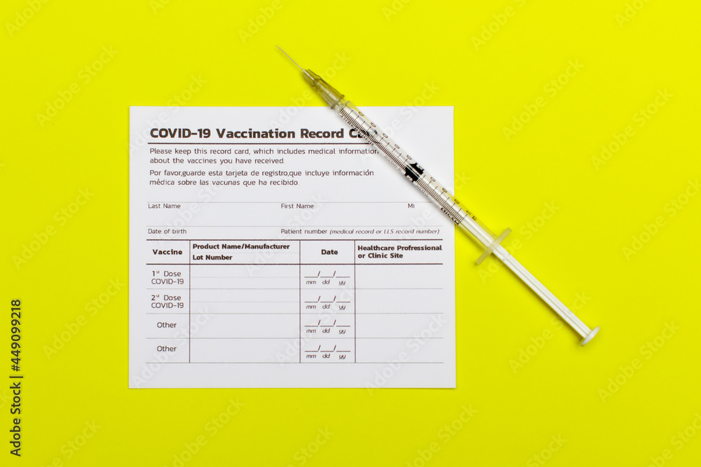 Medical syringe on paper of covid-19 vaccination record card used for ...
