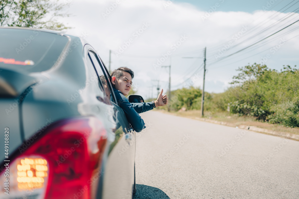 hand giving a thumbs up sign throw the window of a car broken on the ...