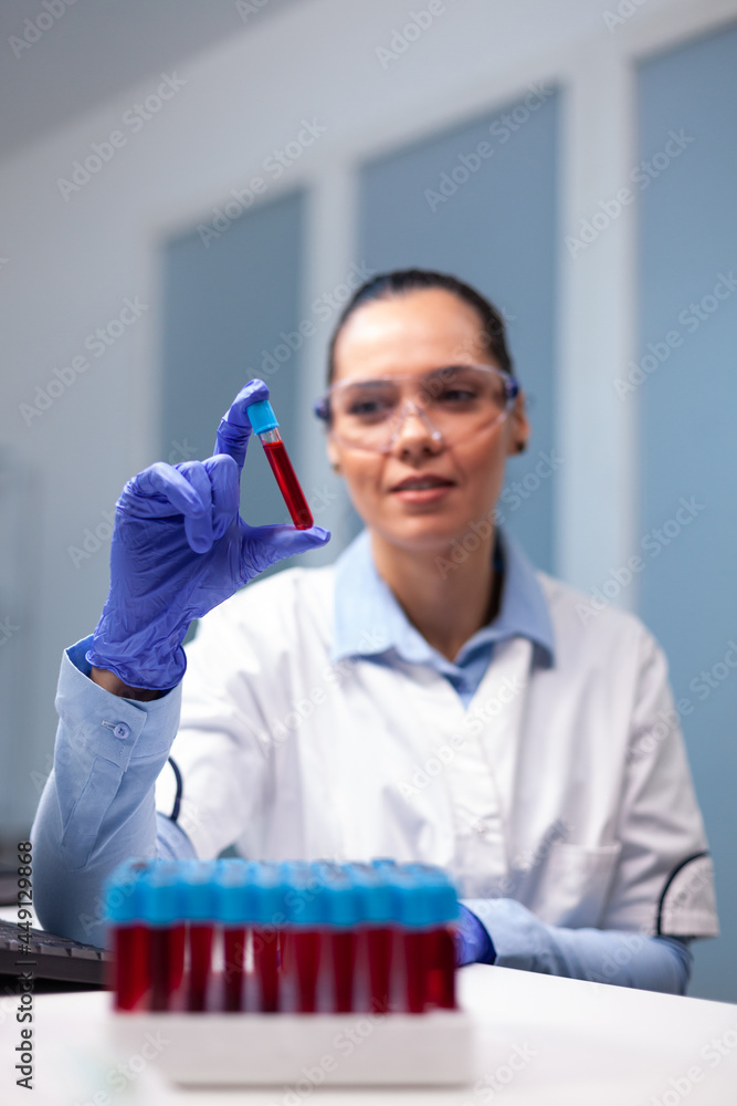 Chemist doctor analyzing dna blood using medical vacutainer working at ...