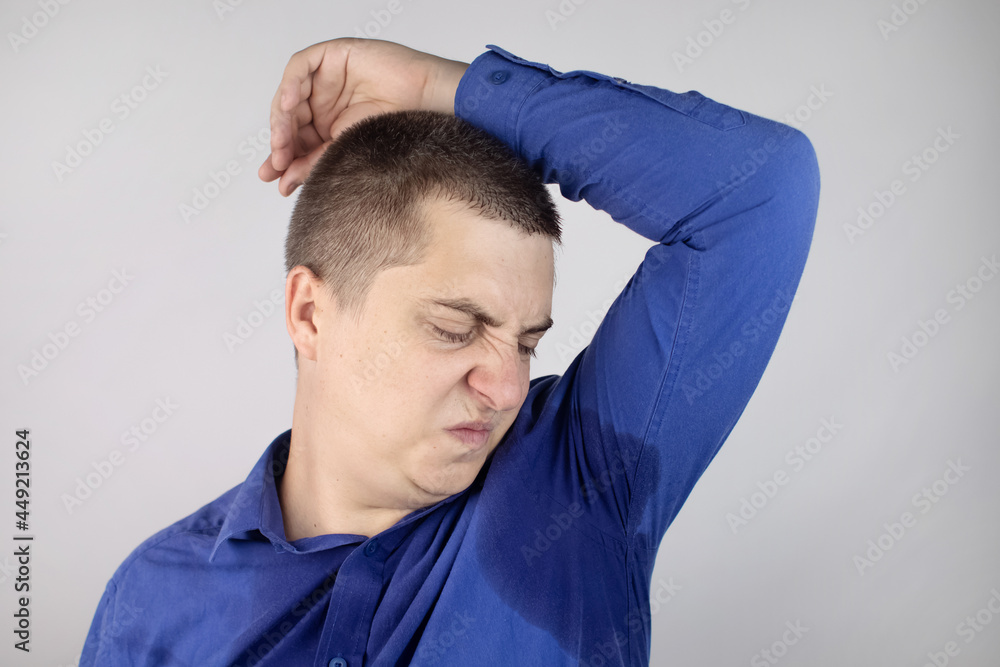 The man shows his sweaty armpits to the camera. Close-up of sweat drops ...