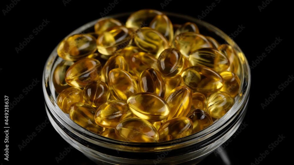 Gold oil capsules Omega 3 on black background. Supplement vitamins in ...