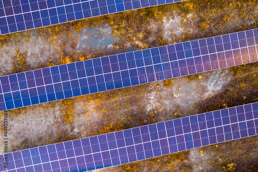 Solar panels at a massive solar power plant at sunset. Hundreds of ...