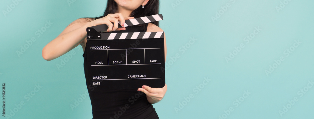 Black clapper board or movie clapperboard in young woman's hand .it use ...