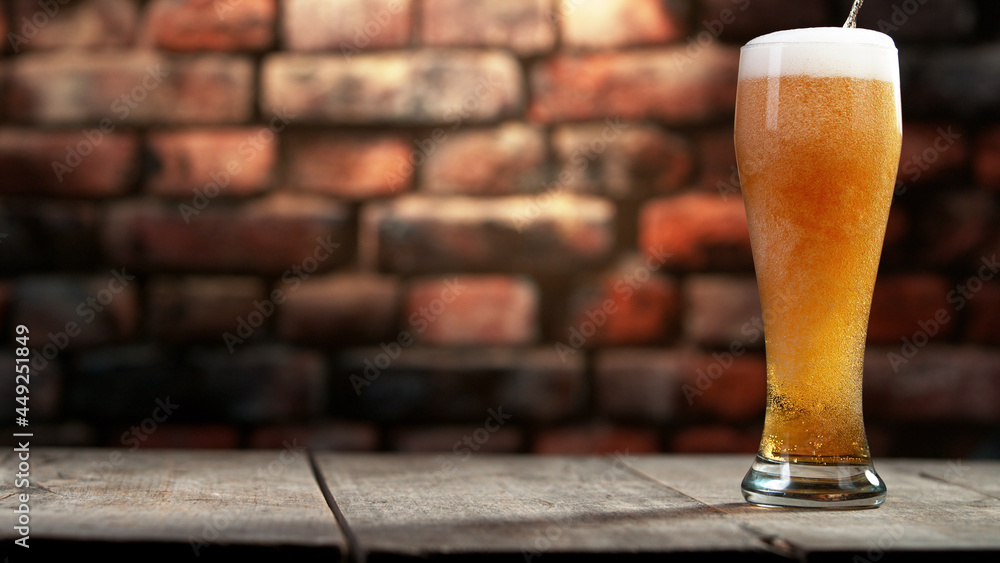 Pouring beer into pint, stylish brick wall on background. Stock Photo ...