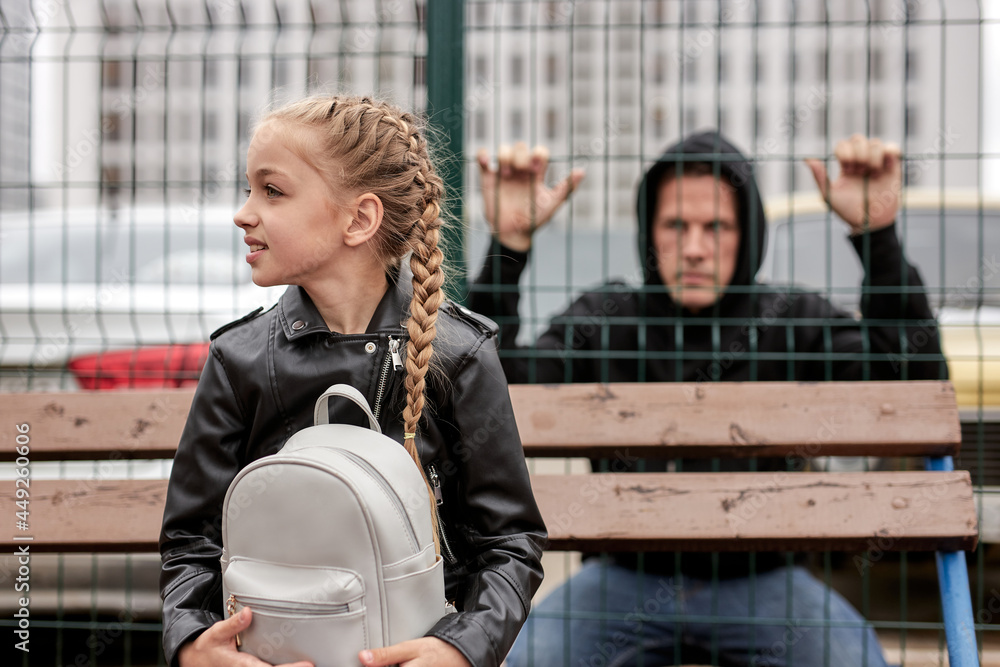Stranger watching at child sitting on playground alone, while walking ...