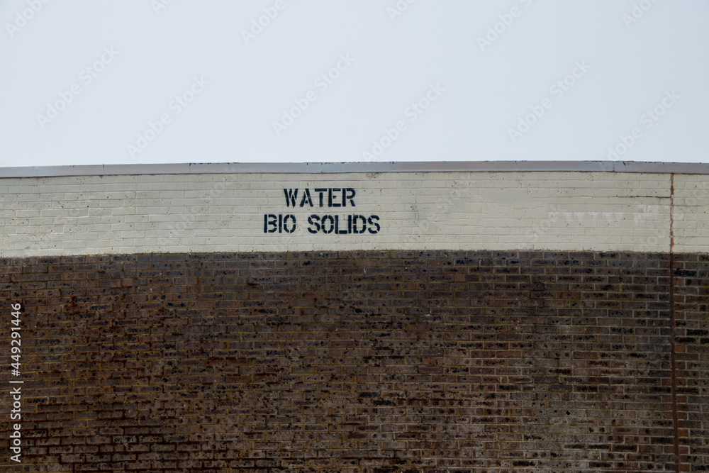 Brown and white brick wall at a waste treatment plant that says, Water ...