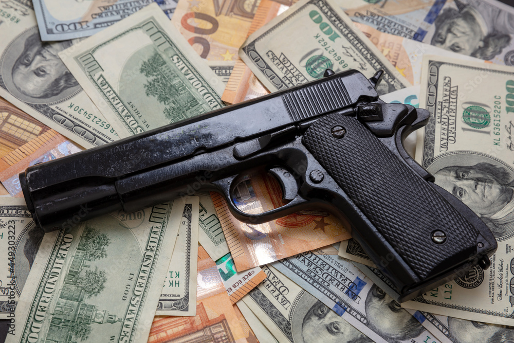Criminal money. Pistol on dollar and euro banknotes background. Mafia ...