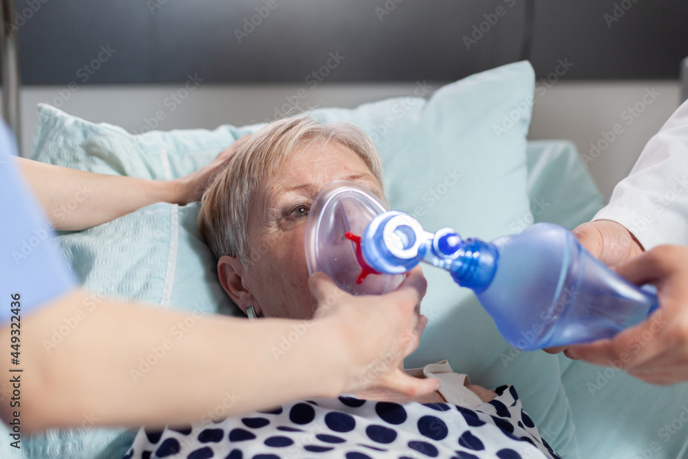 Close up shot of sick senior woman inhale and exhale with help from ...