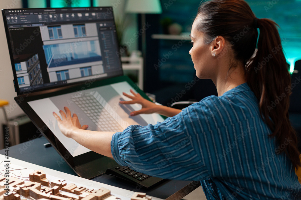 Professional woman architect working on building plan using modern ...