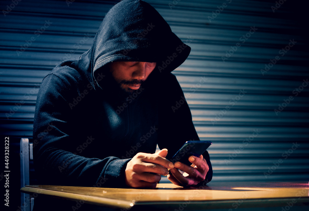 Mysterious man in hoodie on dark background. Dangerous criminal ...