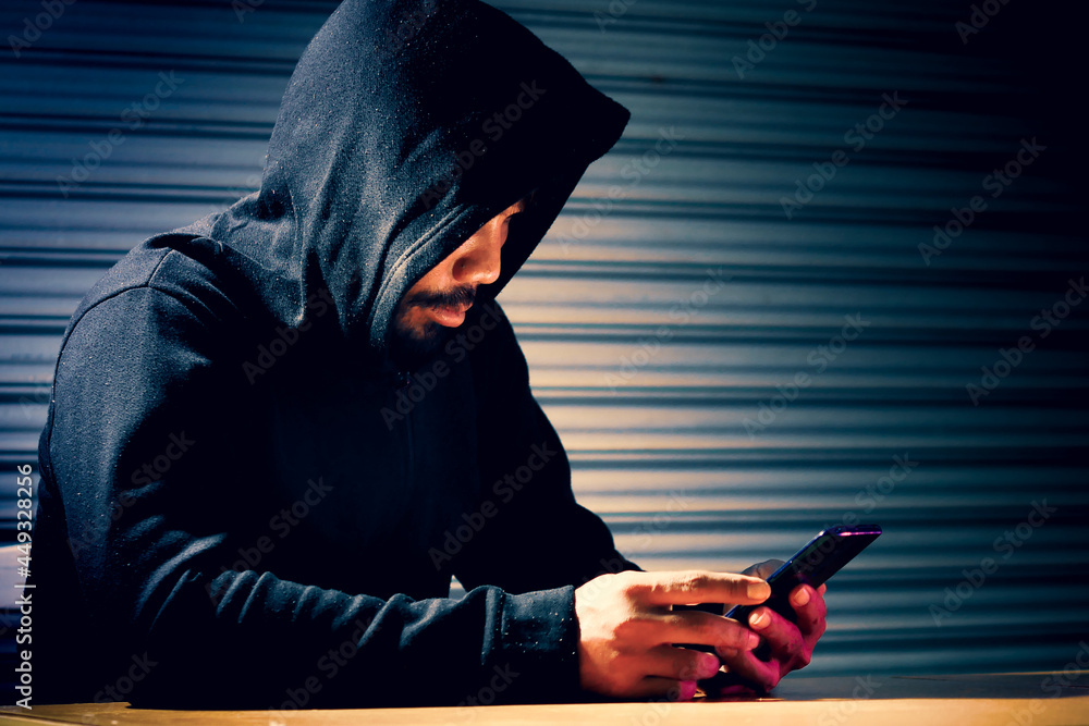 Mysterious man in hoodie on dark background. Dangerous criminal ...
