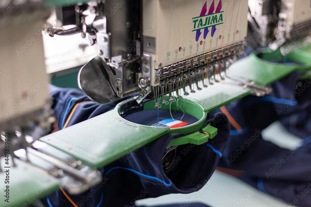 Embroidery machine in progress embroidery company logo on uniform in ...