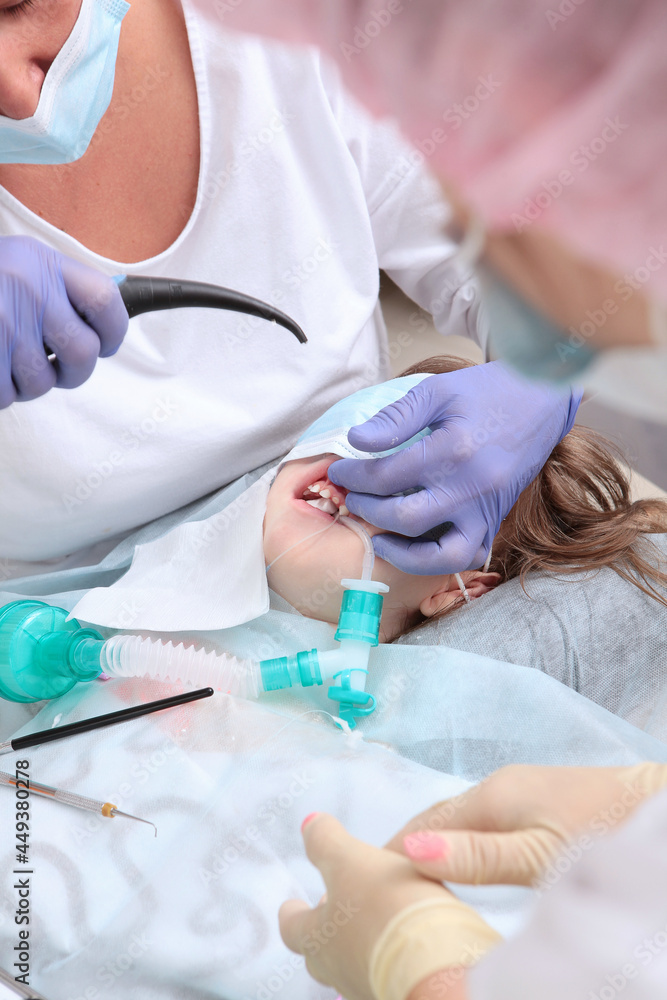 The child is under anesthesia. Caries treatment of primary teeth under ...