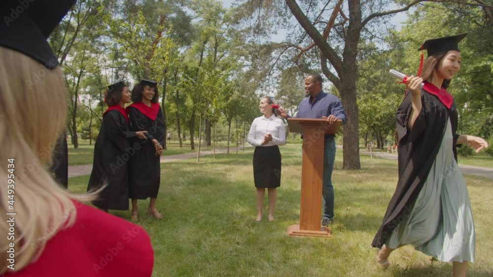 Group of happy cheerful multiracial graduates on graduation gowns and ...