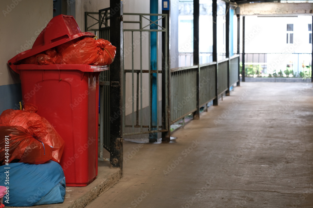 Red infectious waste bin inside the building. where garbage overflows ...