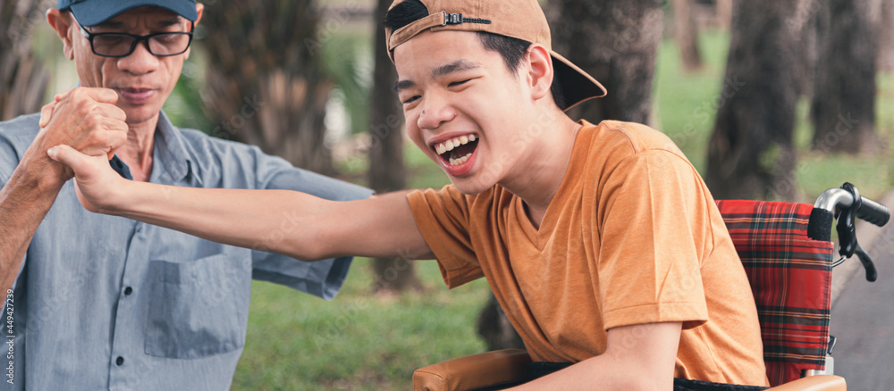 Asian happy disabled teenage boy on wheelchair smiling face with arm ...