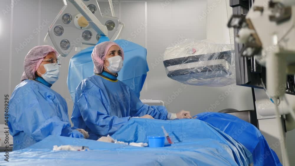 Vascular surgery. Radiologist performs endovascular operation with ...