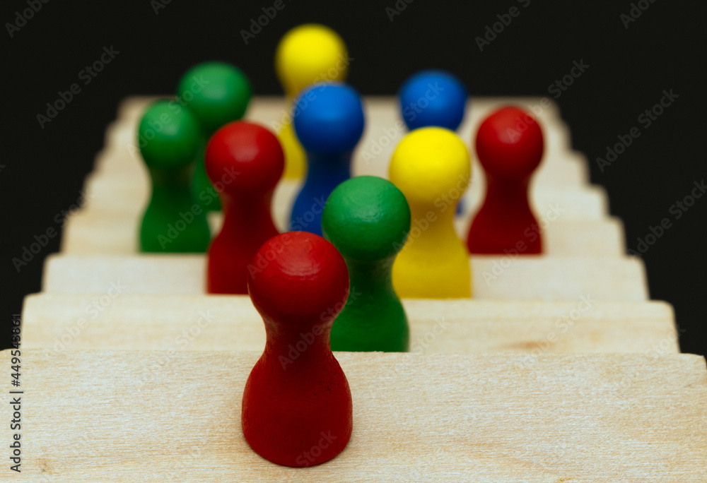 Miniature multi colored figurines on the career ladder of success ...