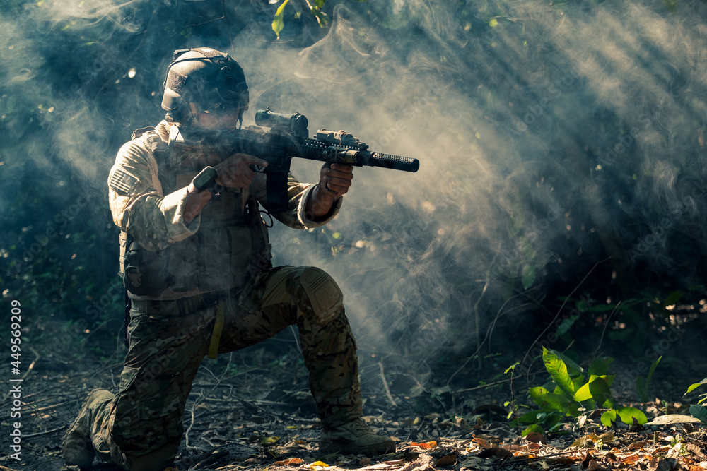 At a natural background, an army soldier in combat uniforms with an ...