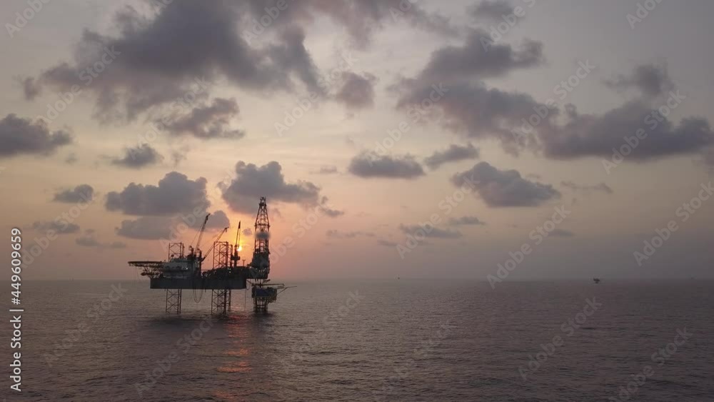 Aerial view of the jack up rig shot during sunset time. Fly around the ...